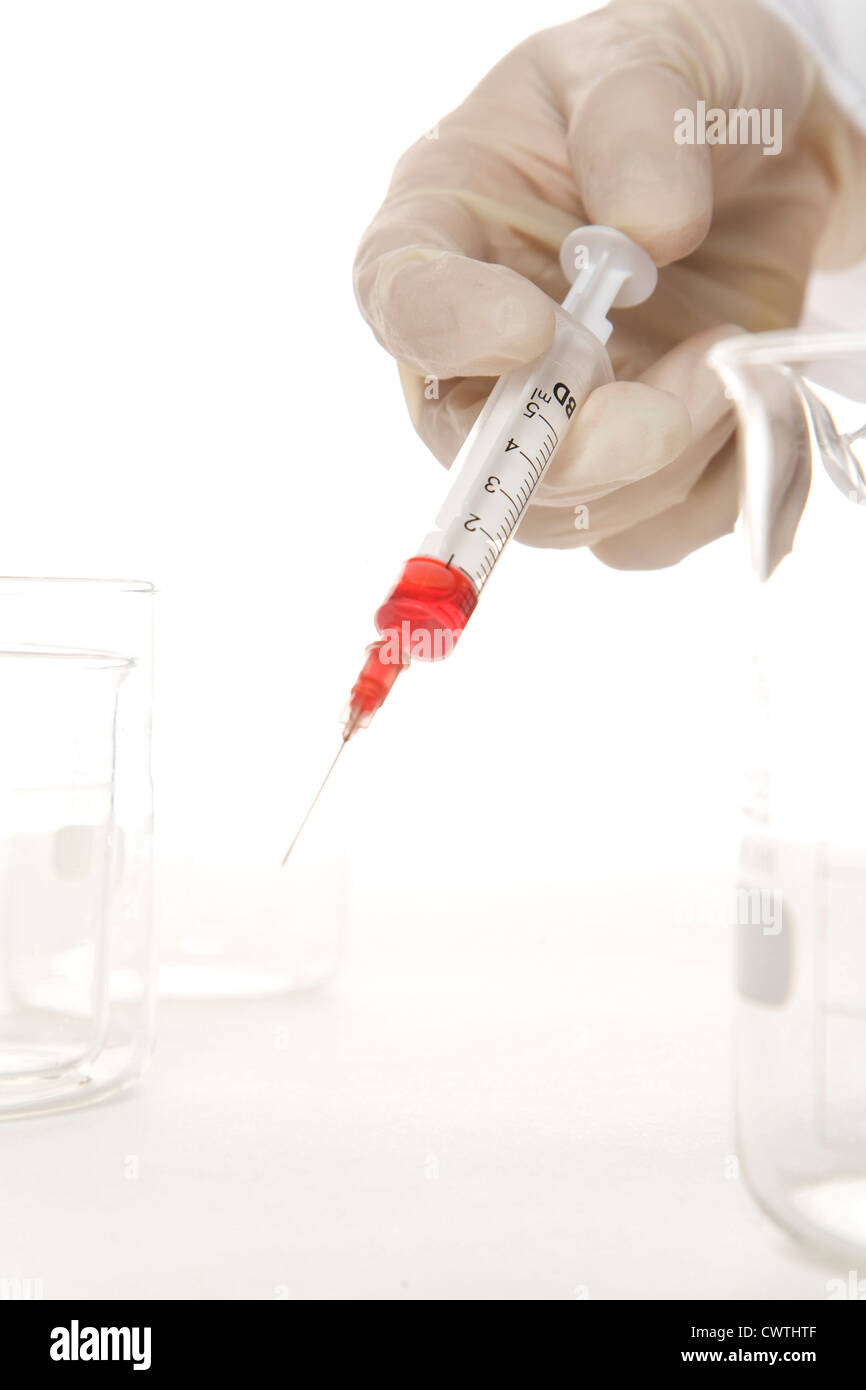 Hand holding syringe Stock Photo - Alamy