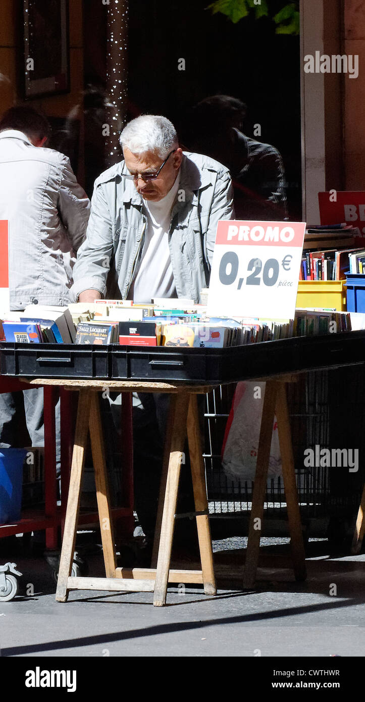 Browsing an old book stall in Paris, France Stock Photo - Alamy