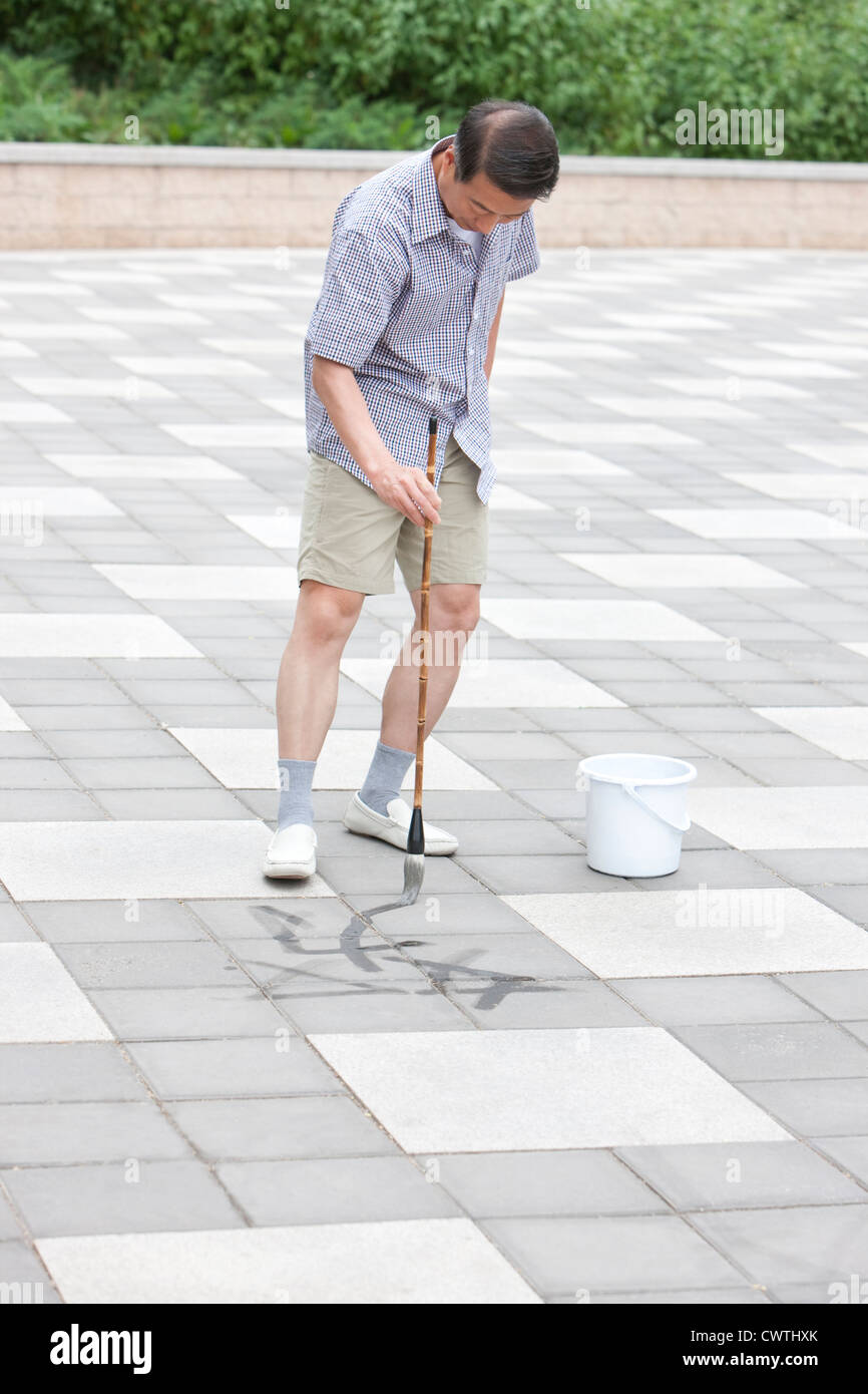 Old man practicing calligraphy in park Stock Photo - Alamy