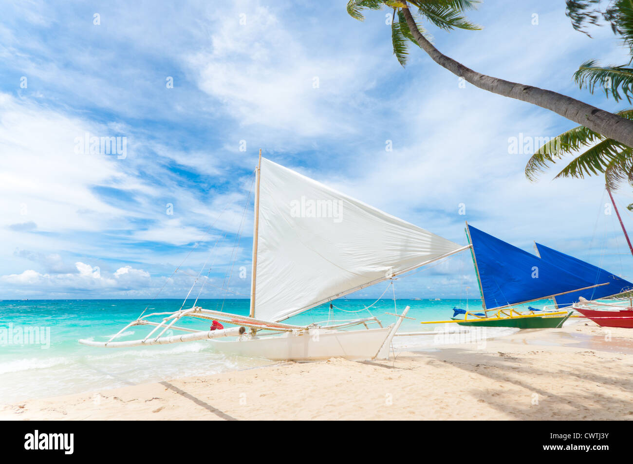traditional paraw sailing boats on white beach on boracay island ...