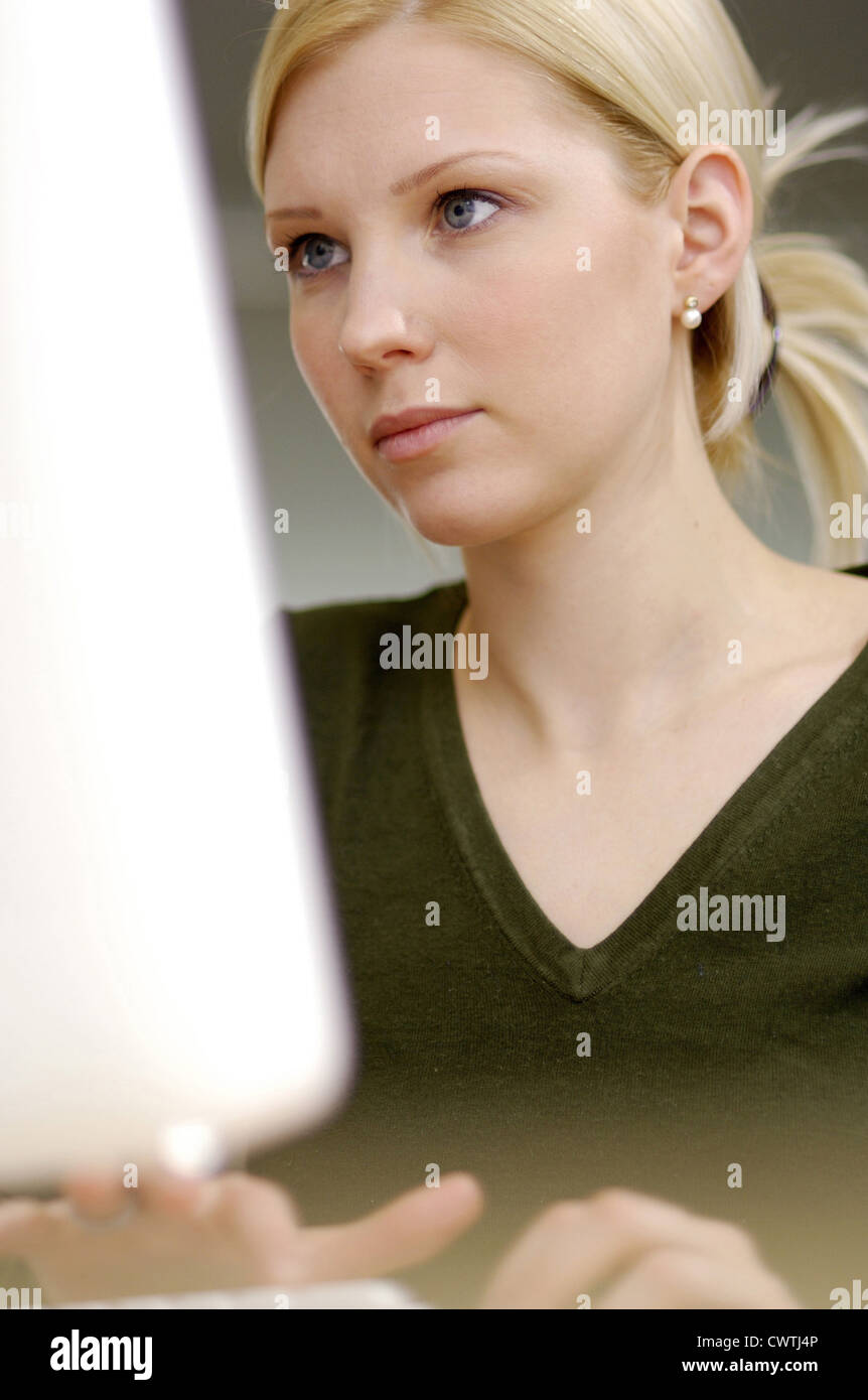 Young woman using computer at desk Stock Photo - Alamy