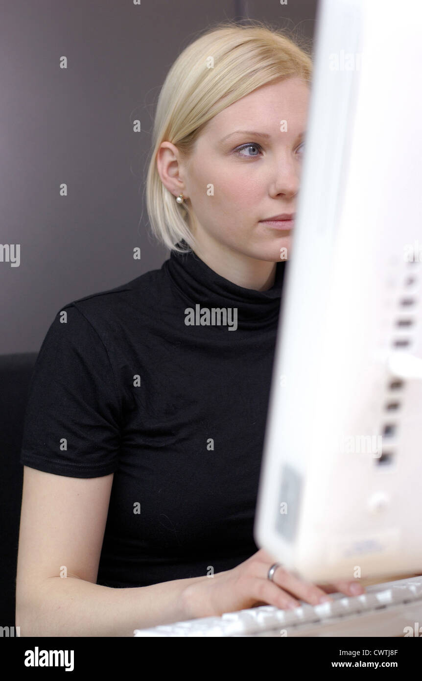 Young woman using computer at desk Stock Photo - Alamy