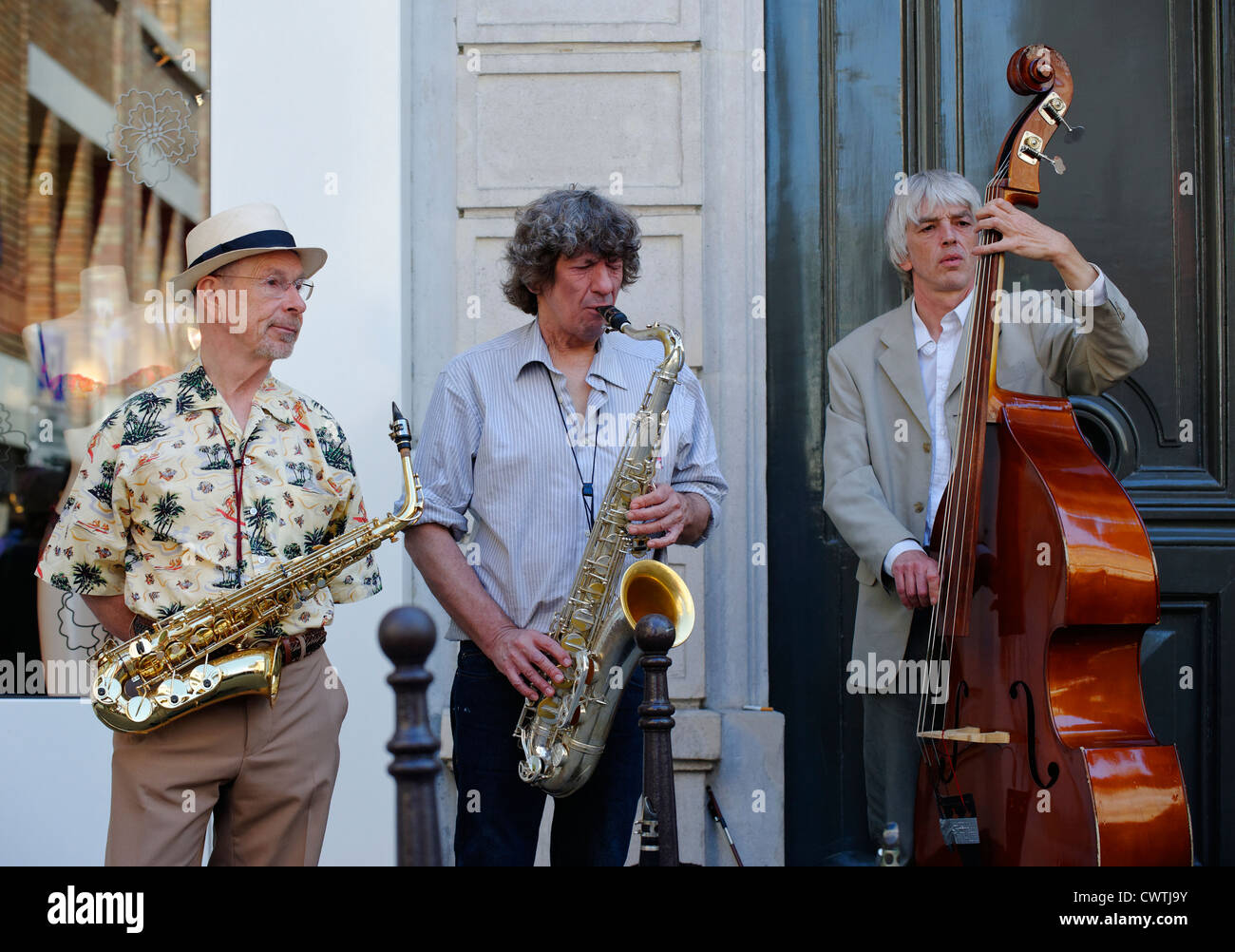 Trio playing saxophones and double bass in a Jazz band busking on the ...