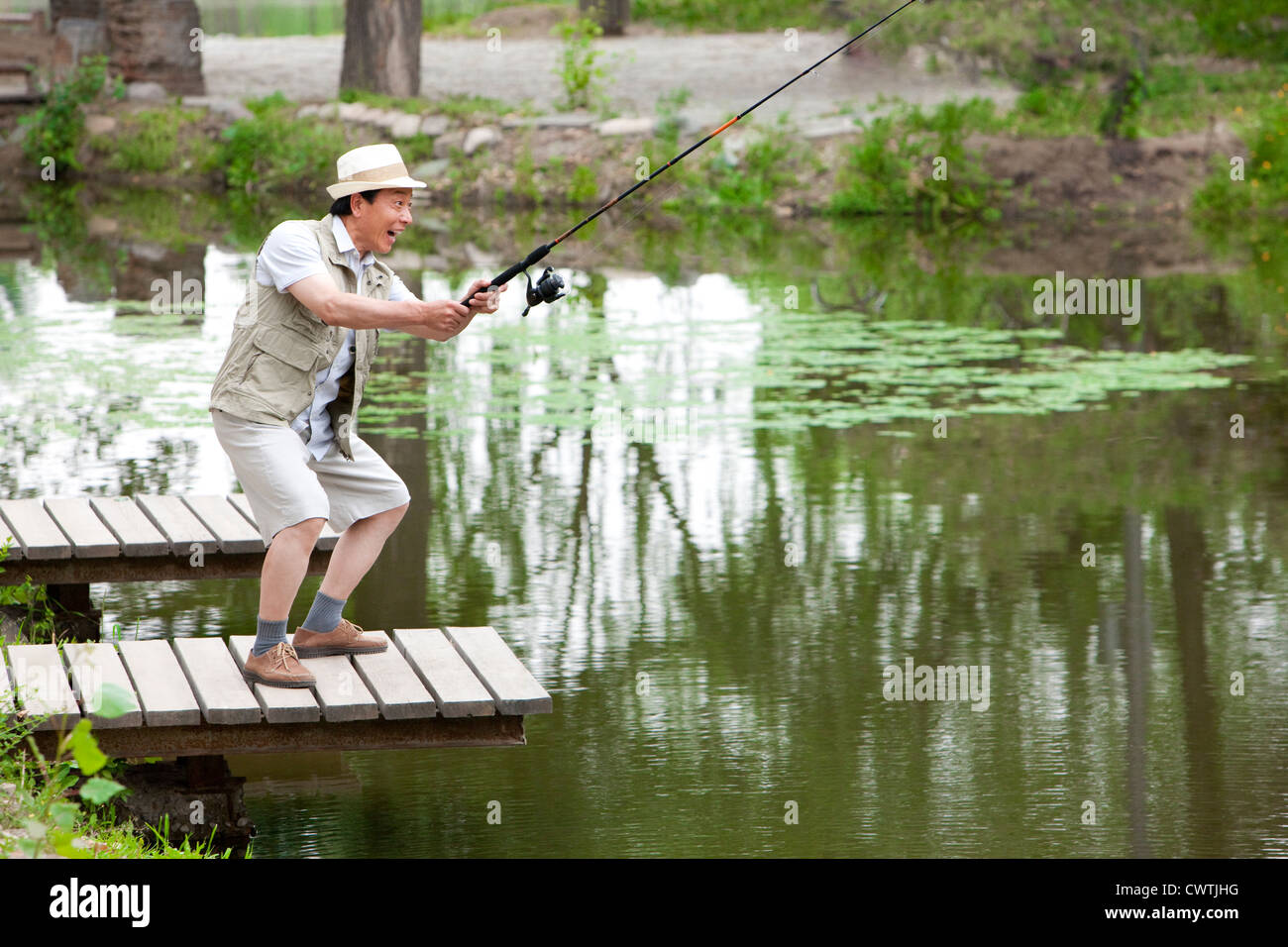 Old man fishing by a pond Stock Photo - Alamy