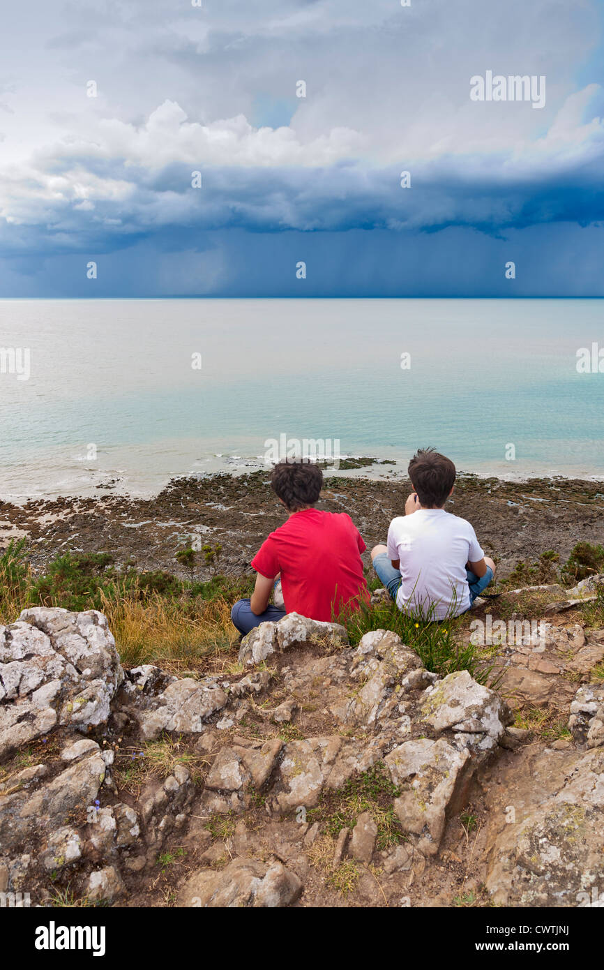 Kids Looking at a Storm over the Sea Stock Photo - Alamy