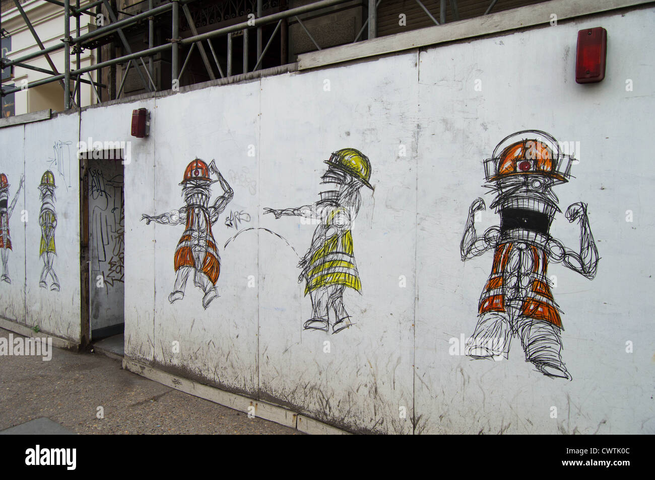 cartoons on construction hording representing workers in hi-vis and ...