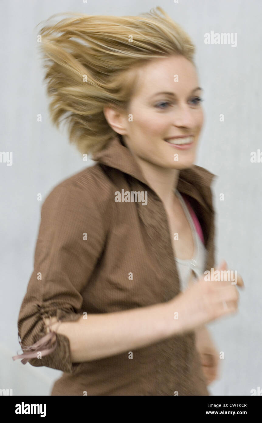 Running young woman wearing brown blouse Stock Photo - Alamy
