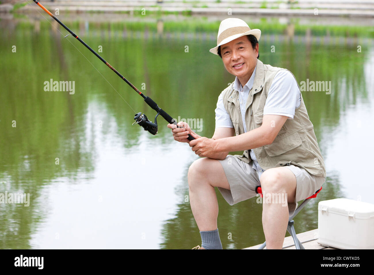 Old man fishing by a pond Stock Photo - Alamy