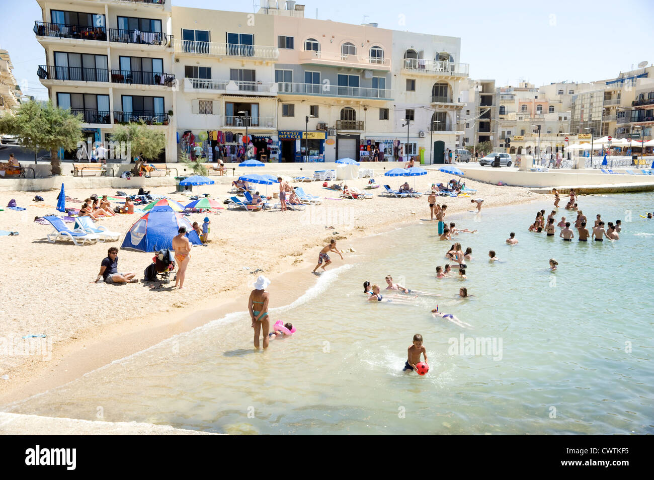 Tourists and locals on the beach at Marsalforn on the island of Gozo ...