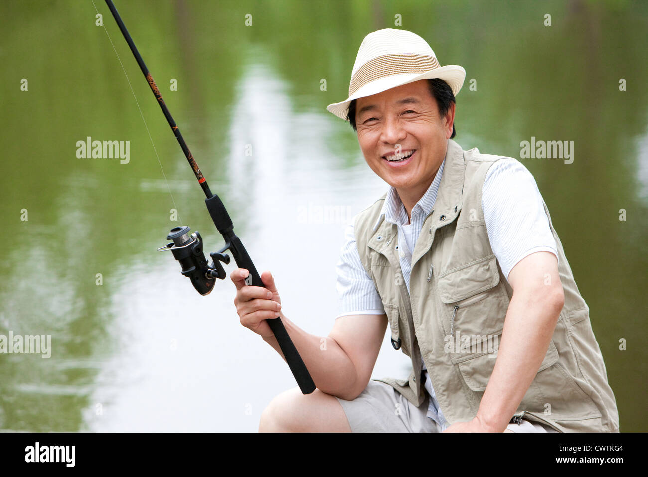 Old man fishing by a pond Stock Photo - Alamy