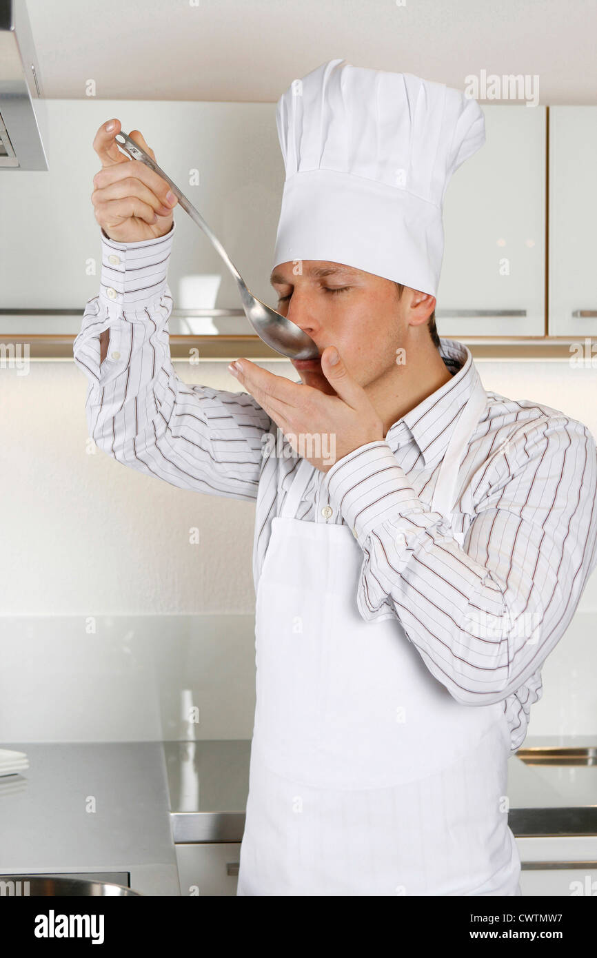 Cook in kitchen tasting food Stock Photo - Alamy