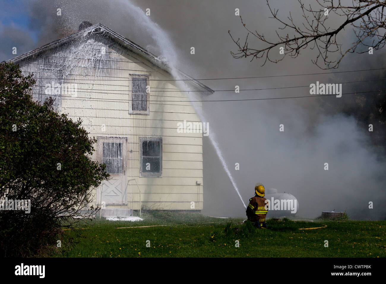 Volunteer firefighters fighting a house fire Stock Photo - Alamy