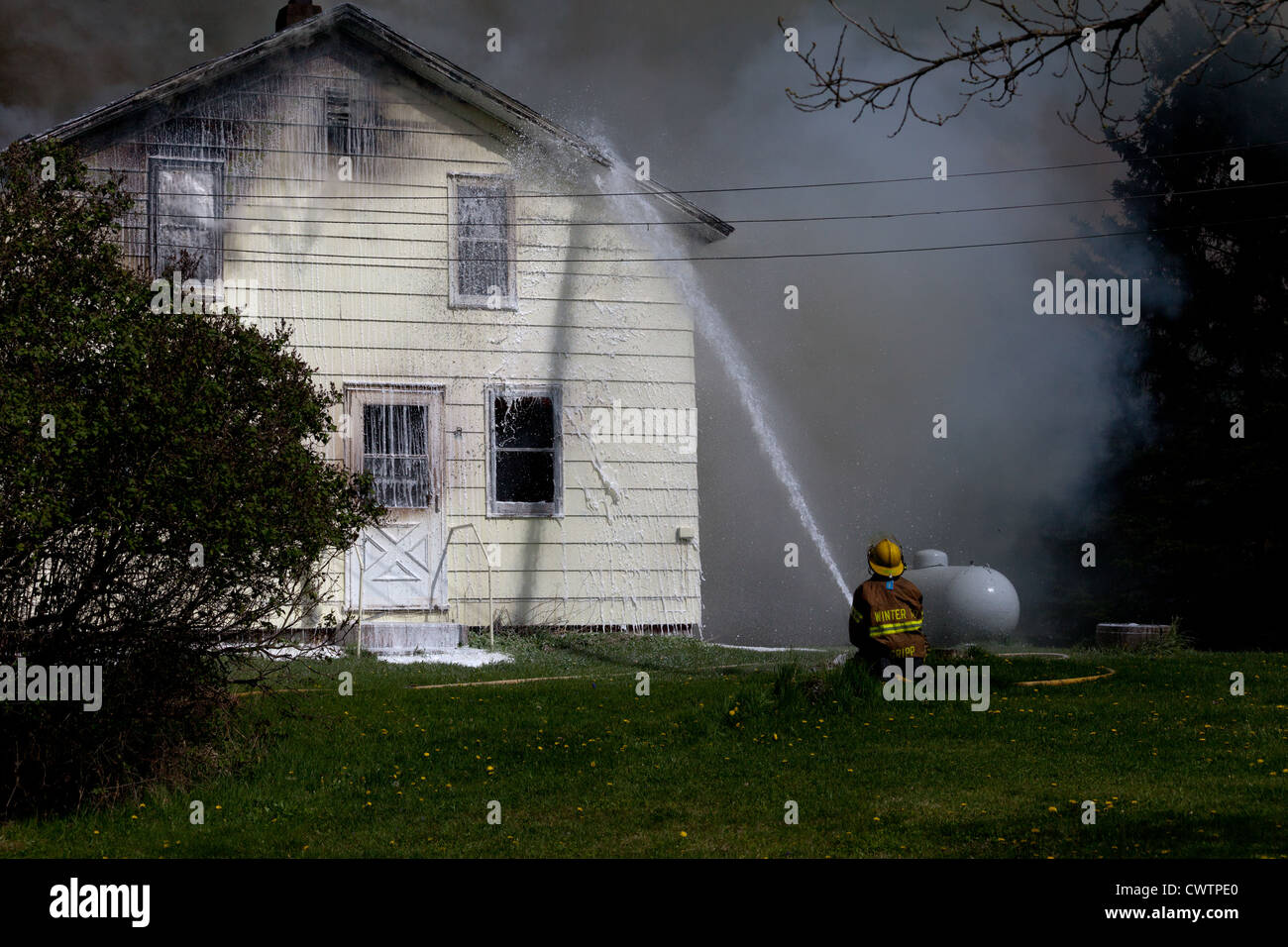 Volunteer firefighters fighting a house fire Stock Photo - Alamy