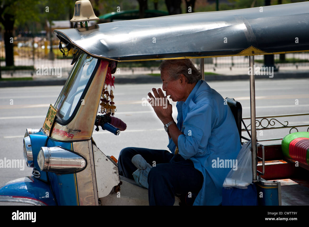 Tuk tuk driver praying Stock Photo - Alamy