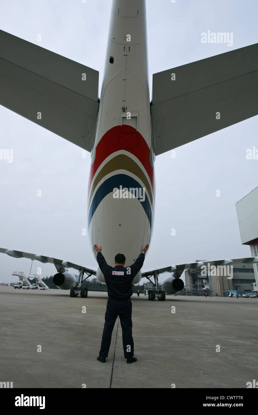 A Chinese worker directs a new Airbus A330 of China Eastern Airlines in ...