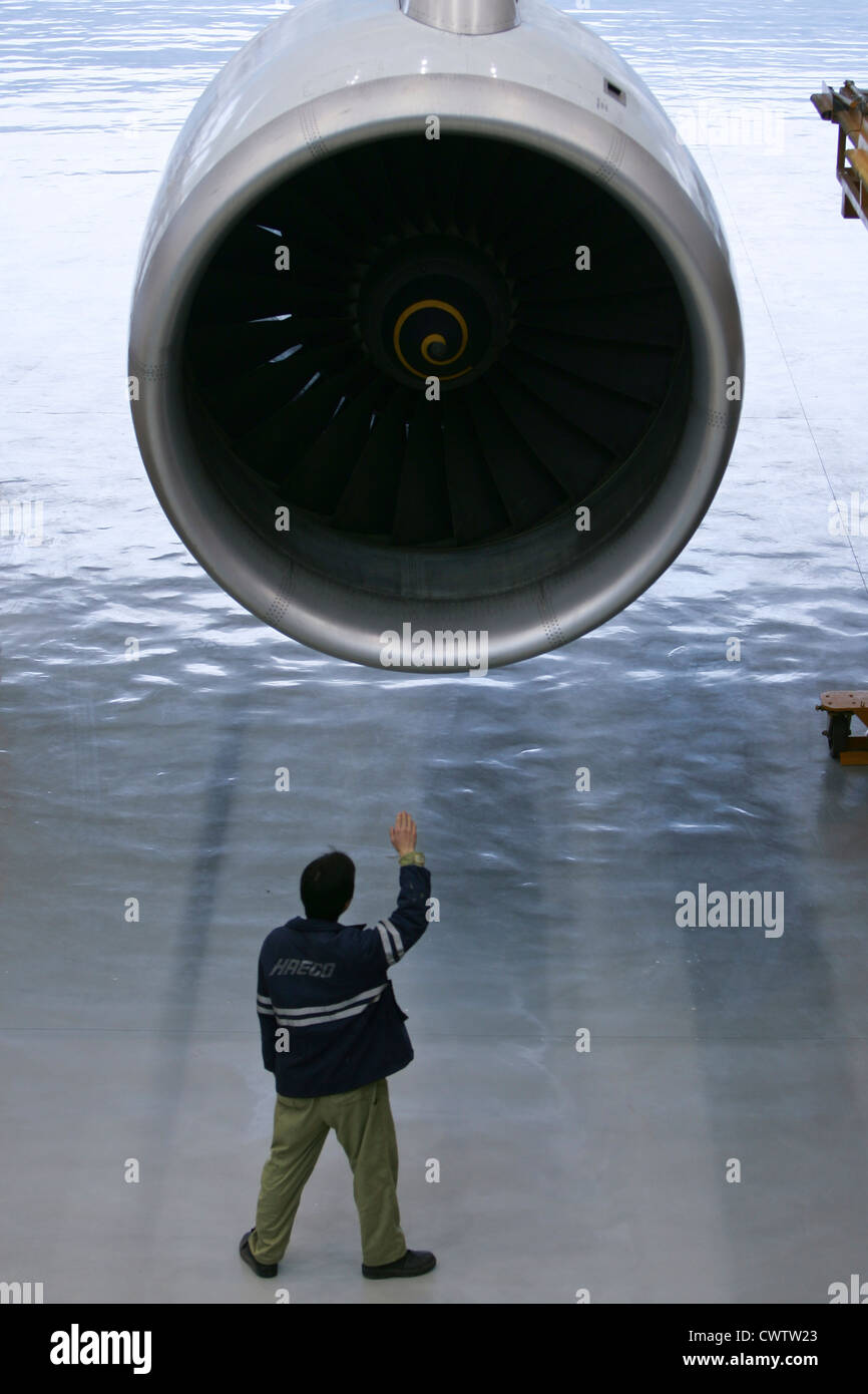 A Chinese worker directs a Cathay Pacific cargo plane in Xiamen, China ...