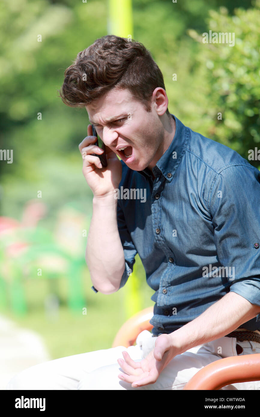 Young man angry and shouting on telephone Stock Photo - Alamy