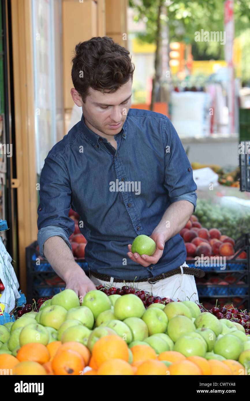 Young handsome customer choosing fruits at grocery store Stock Photo ...