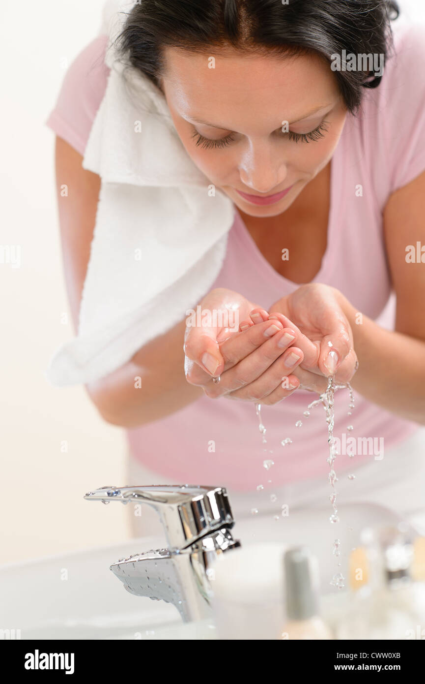 Woman washing face with water above bathroom sink Stock Photo - Alamy