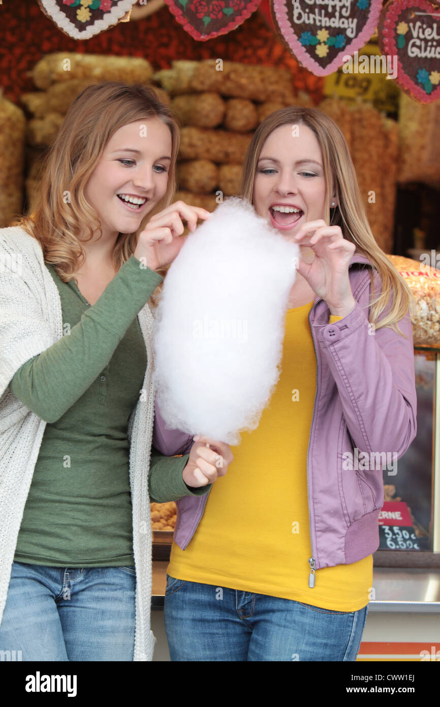 Two happy women on a funfair eating cotton candy Stock Photo - Alamy
