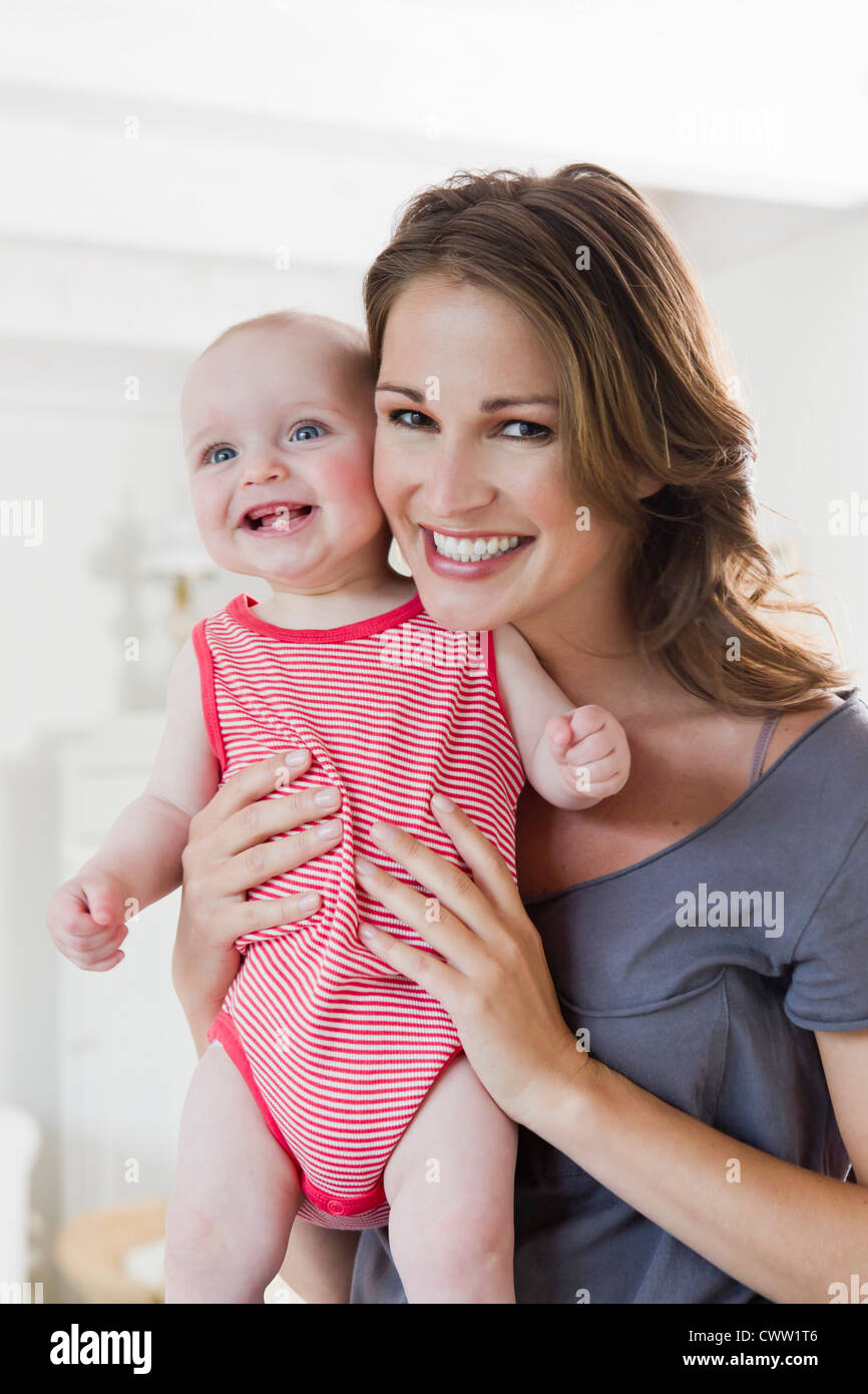 Smiling woman holding baby Stock Photo - Alamy