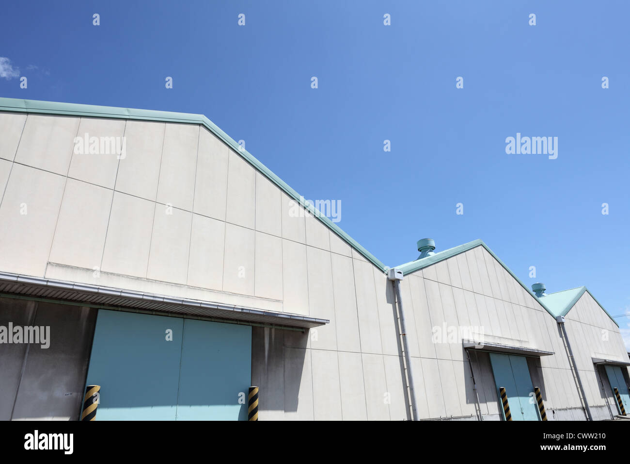 Large industrial warehouse against a blue sky Stock Photo - Alamy