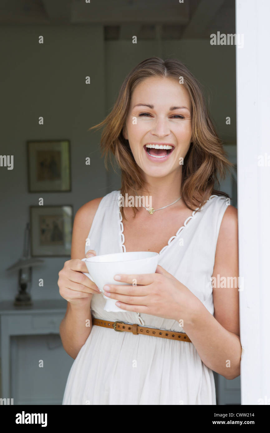 Smiling woman having cup of coffee Stock Photo - Alamy