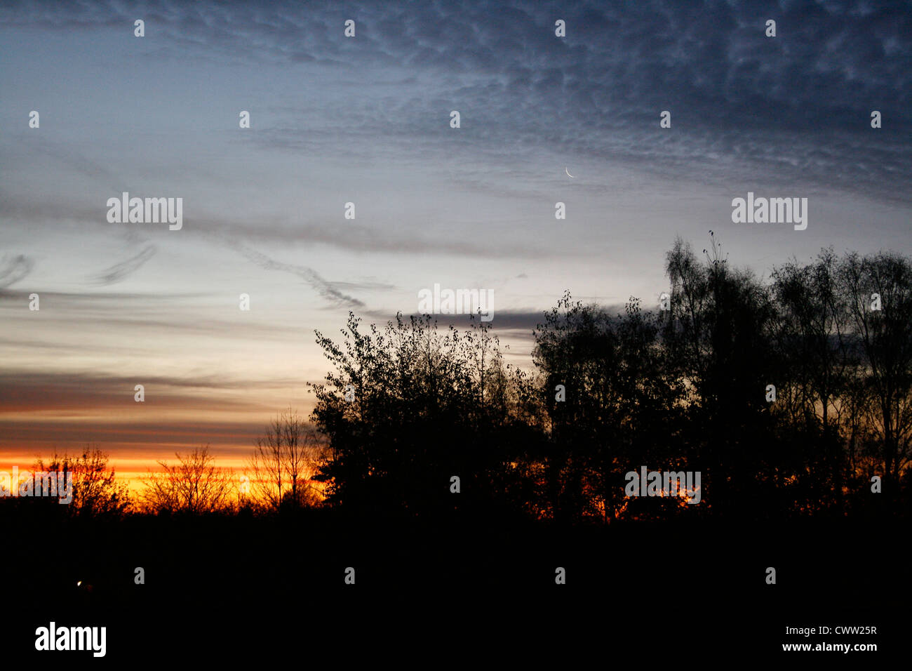 Sunrise with the moon Stock Photo - Alamy