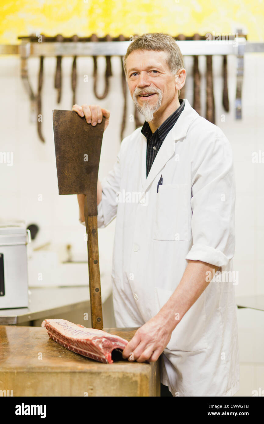 Butcher holding large knife and meat Stock Photo - Alamy