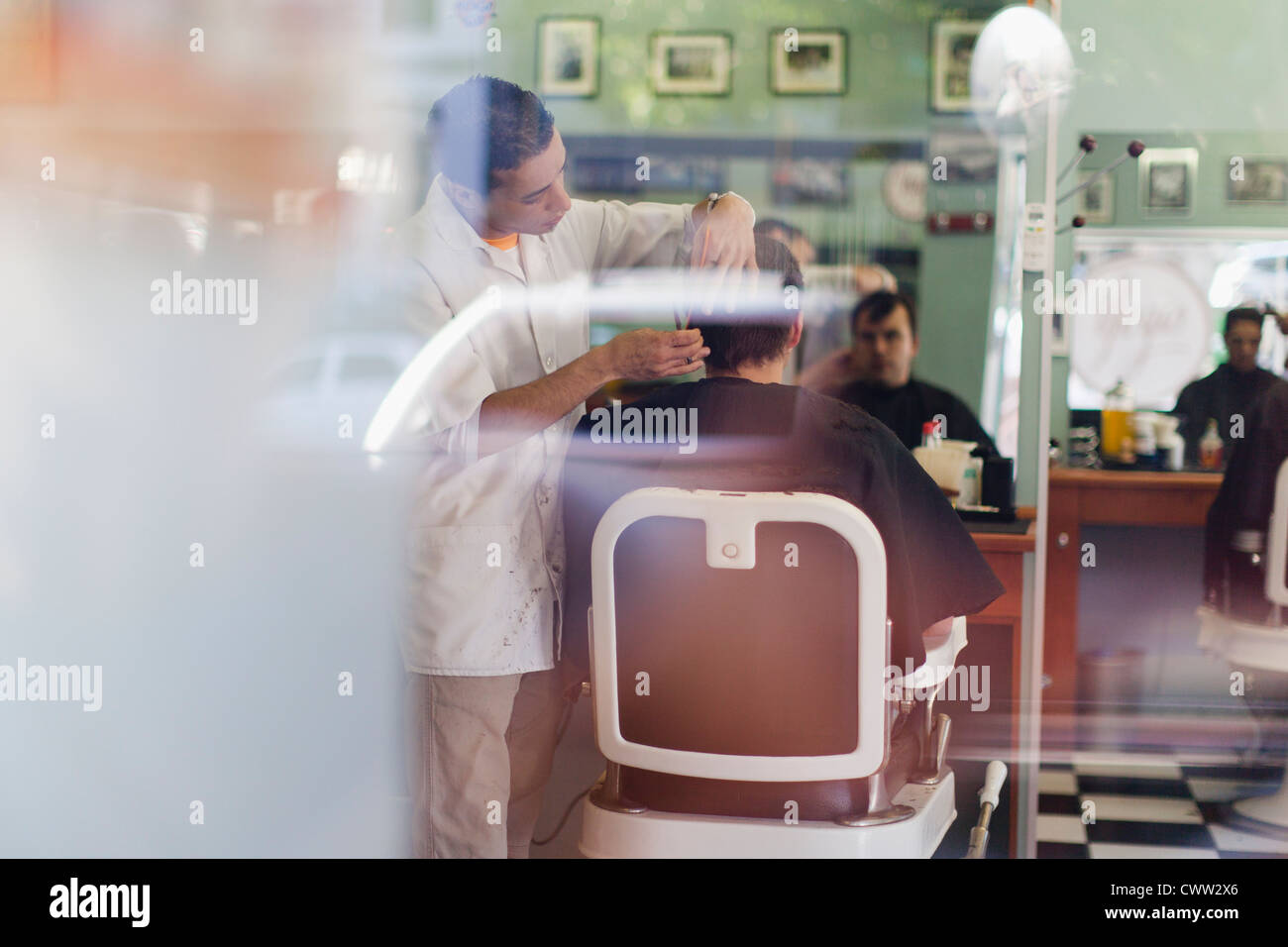 Barber working on client in shop Stock Photo - Alamy