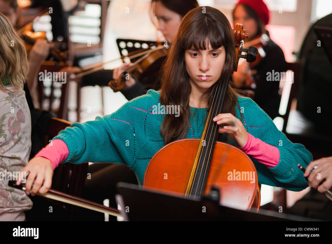 Cello player practicing with group Stock Photo - Alamy