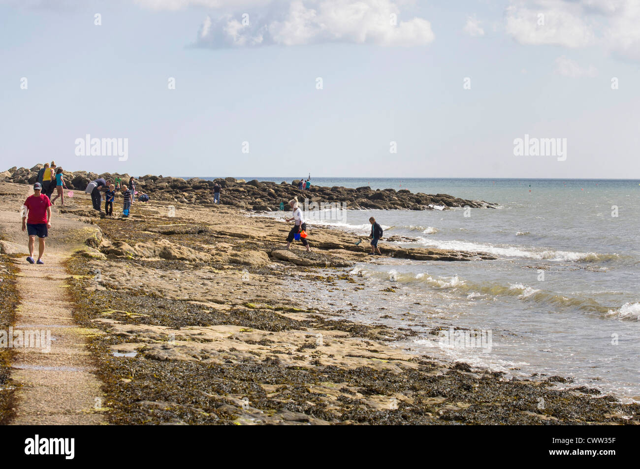 Families at play around the lower footpath on Filey Brigg Stock Photo ...