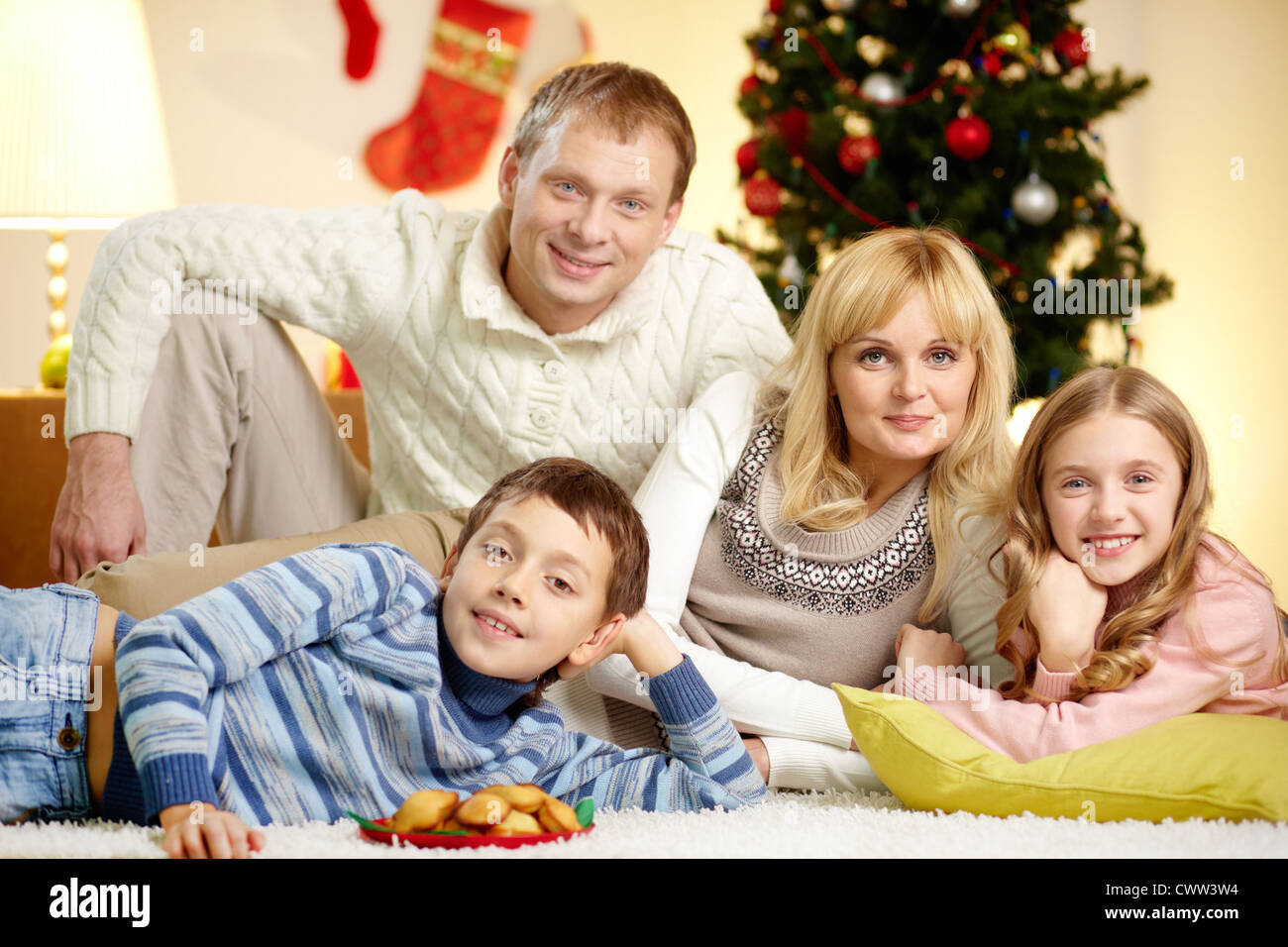 Portrait of four happy family members looking at camera with smiles ...