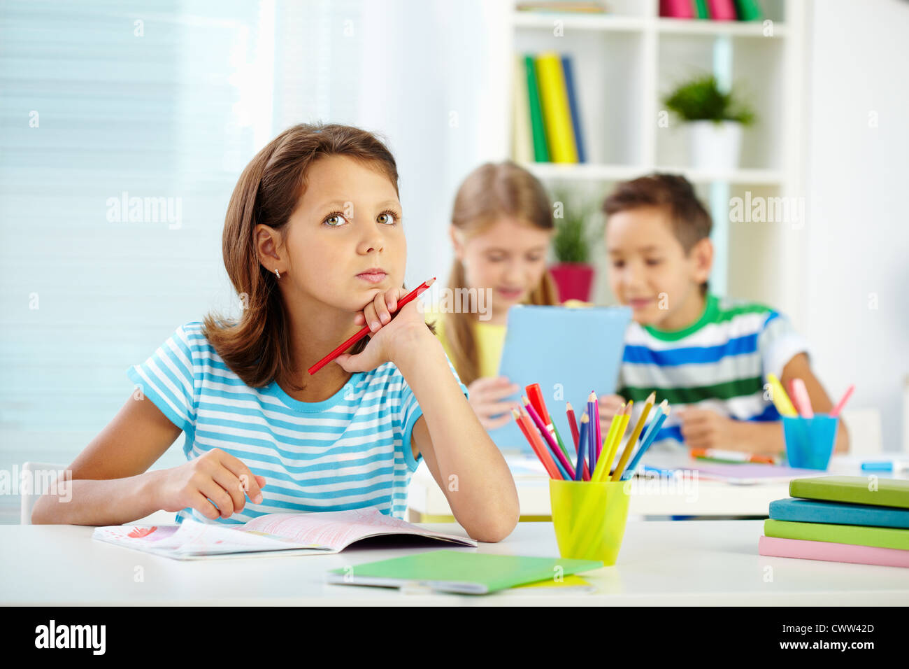 Portrait of lovely girl concentrating on drawing at workplace with ...