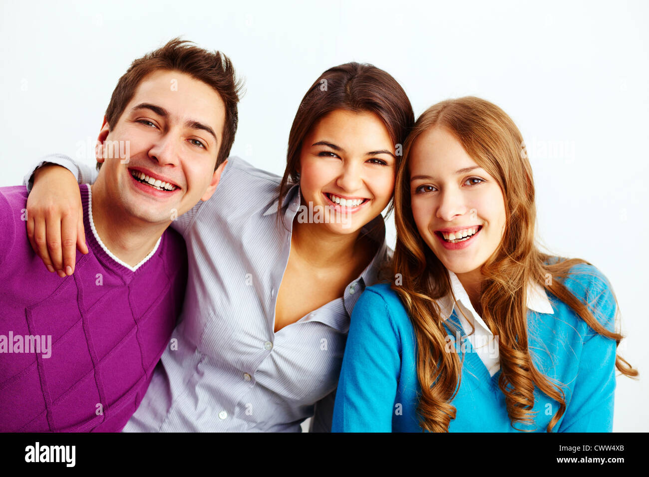 Portrait of three joyful friends looking at camera on white background ...
