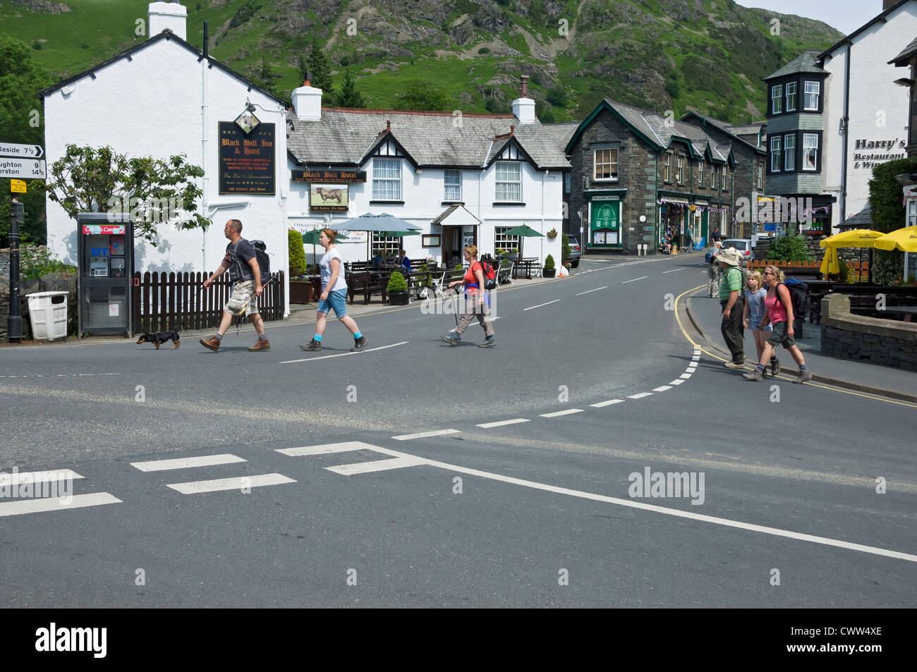 People tourists visitors walkers in Coniston village in summer Cumbria ...