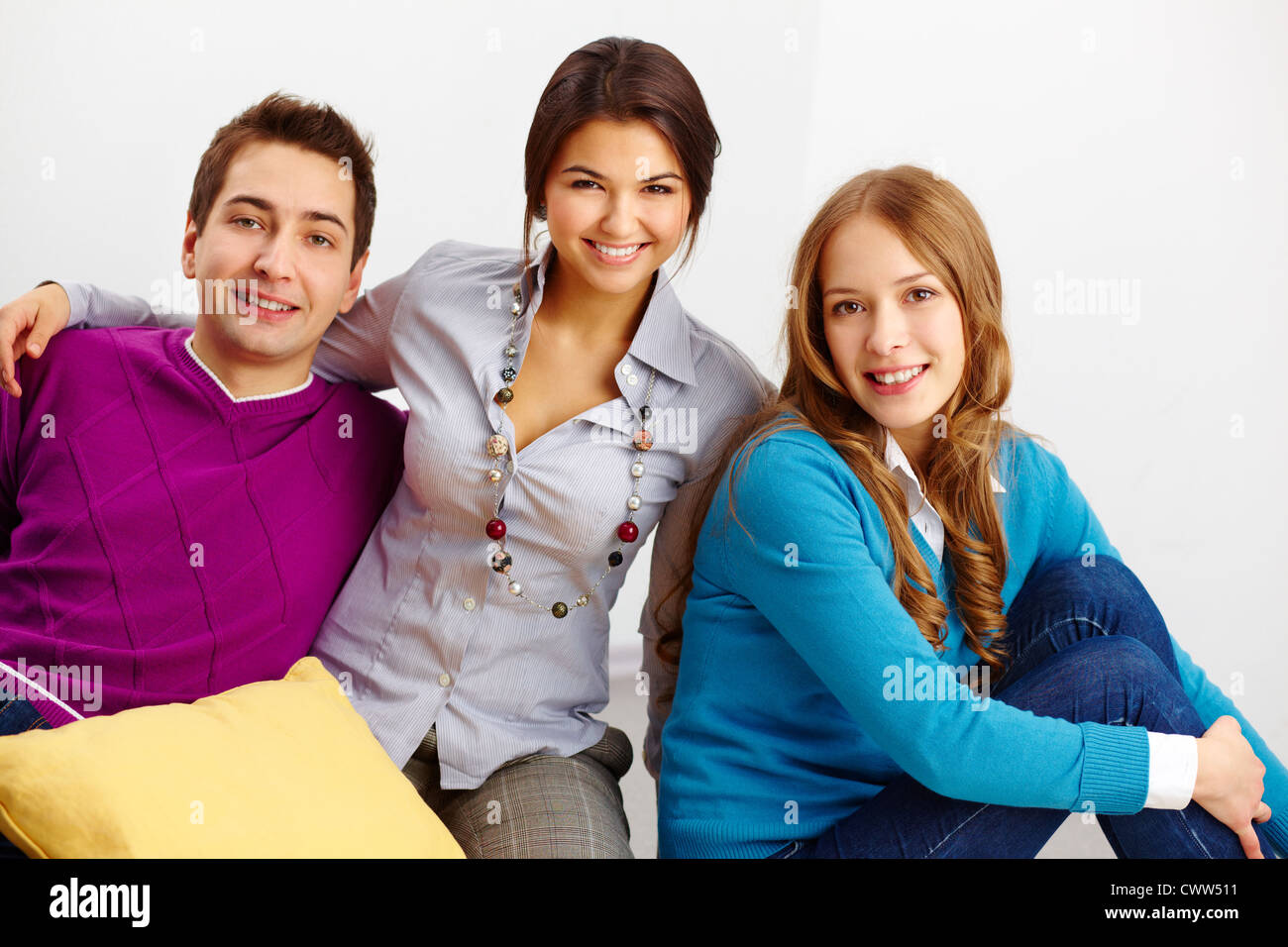 Portrait of three smart friends looking at camera on white background ...