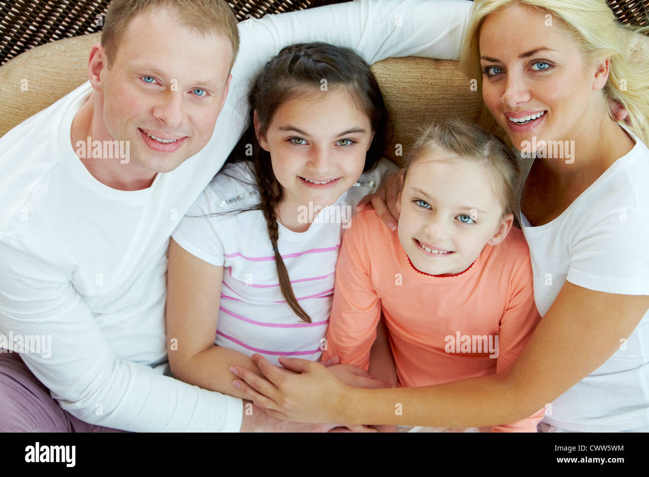 Portrait of happy family with two children sitting at home Stock Photo ...