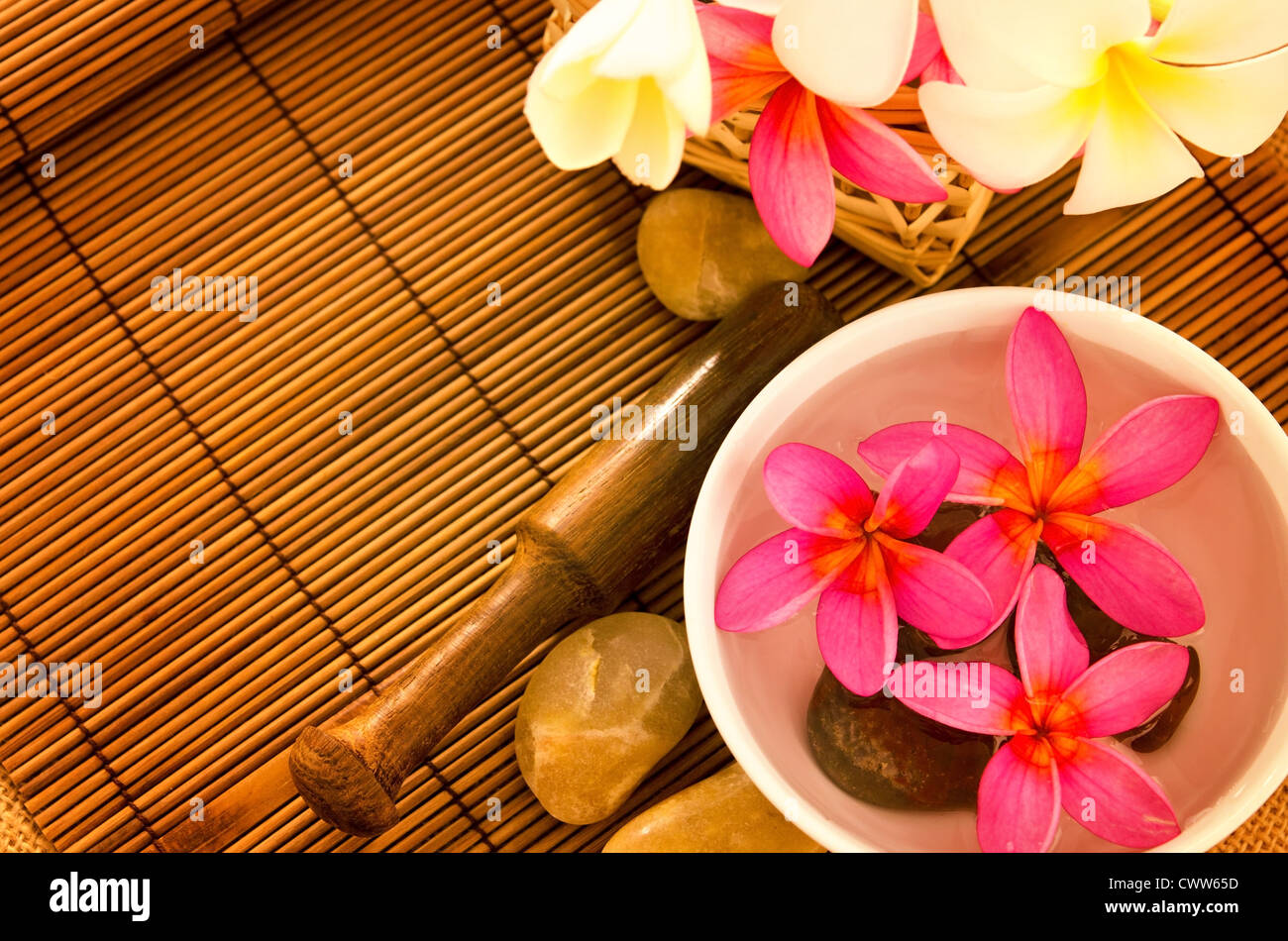 Tropical spa with Frangipani flowers on water. Low lighting, suitable ...