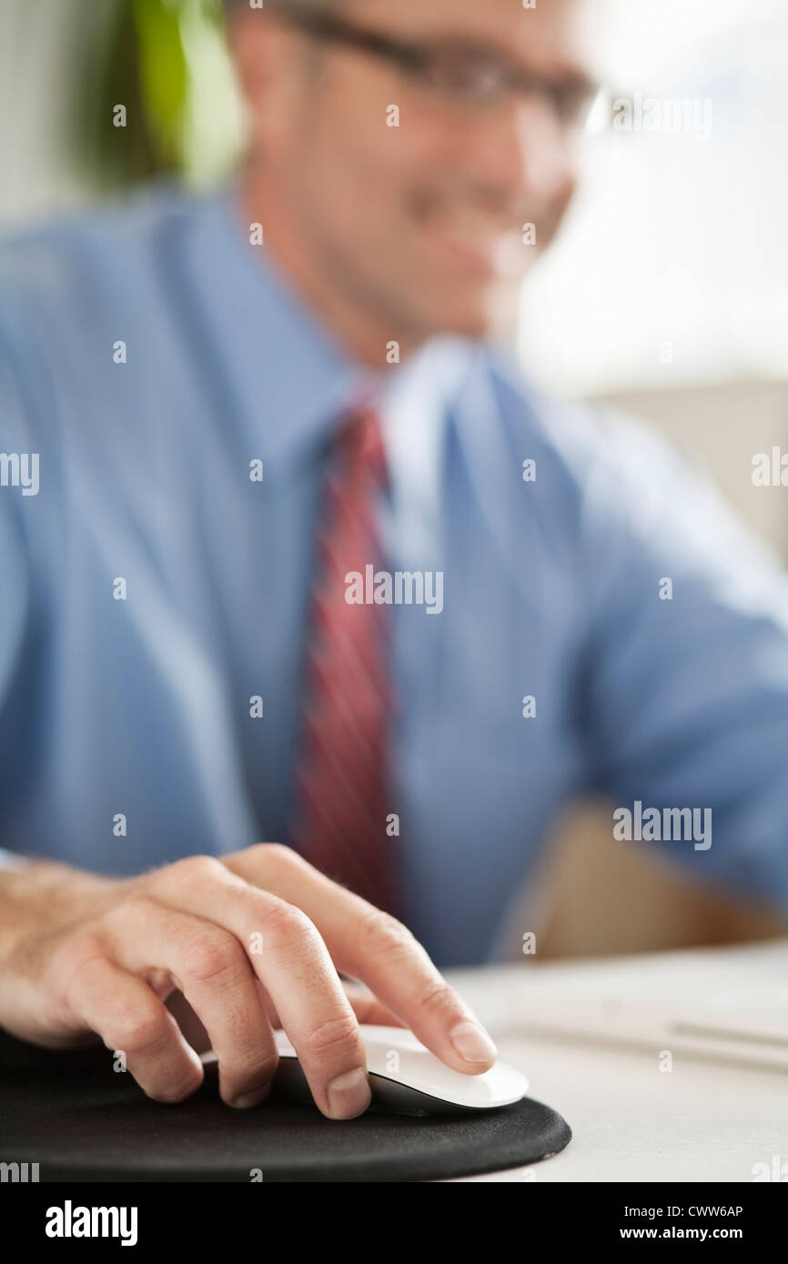 Businessman clicking mouse at desk Stock Photo - Alamy