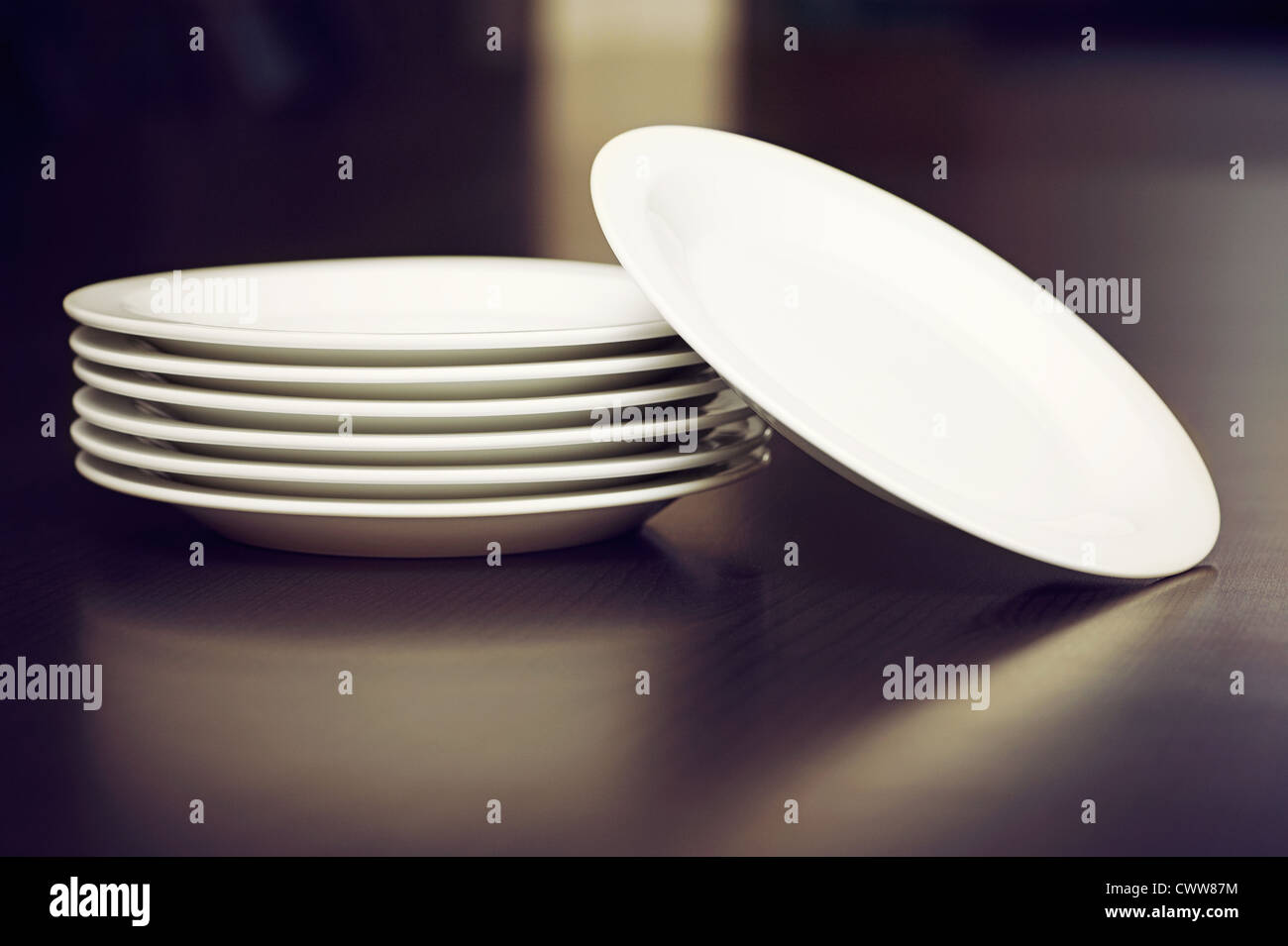 Stack of white plates on a table Stock Photo - Alamy