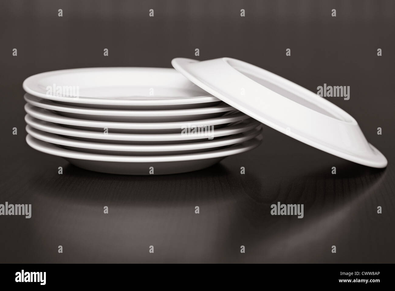 Stack of white plates on a table Stock Photo - Alamy