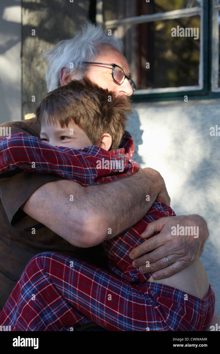 Older man hugging grandson outdoors Stock Photo - Alamy