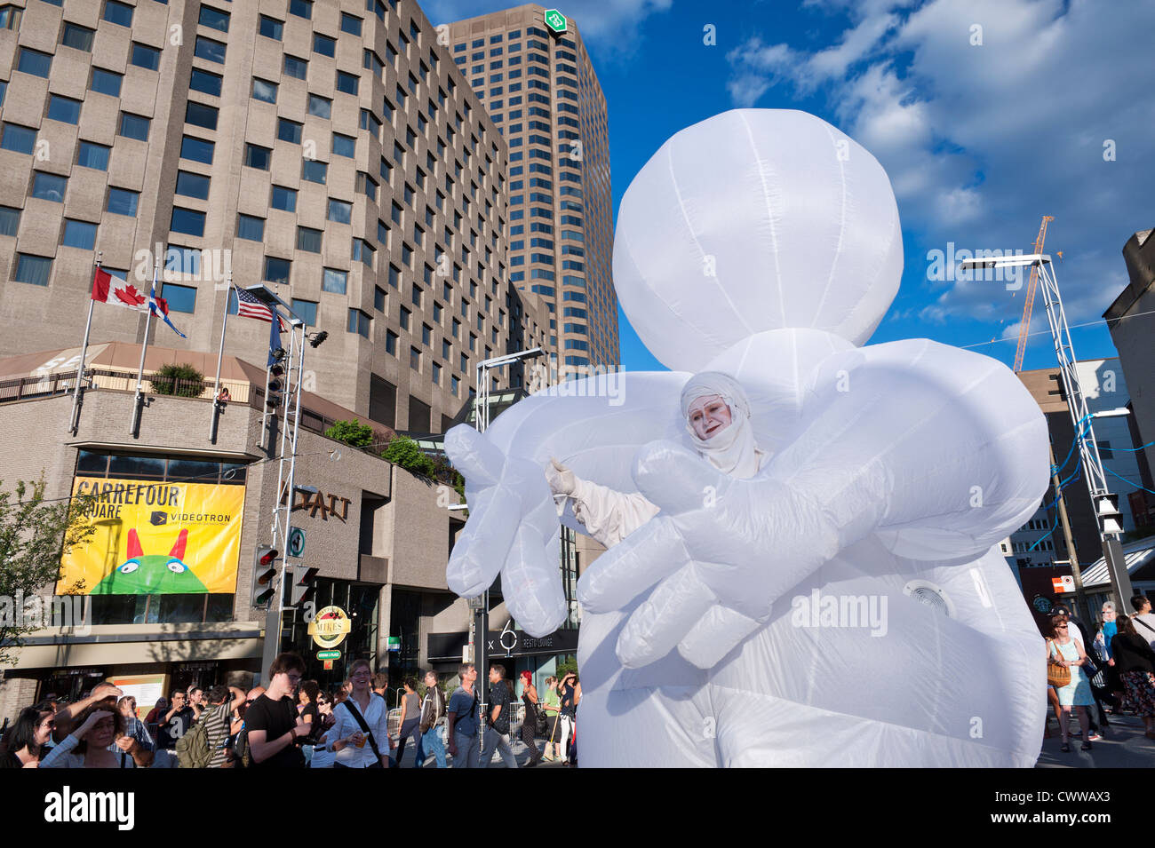 Stilt artist draped in an inflated white costume walking on Place des ...