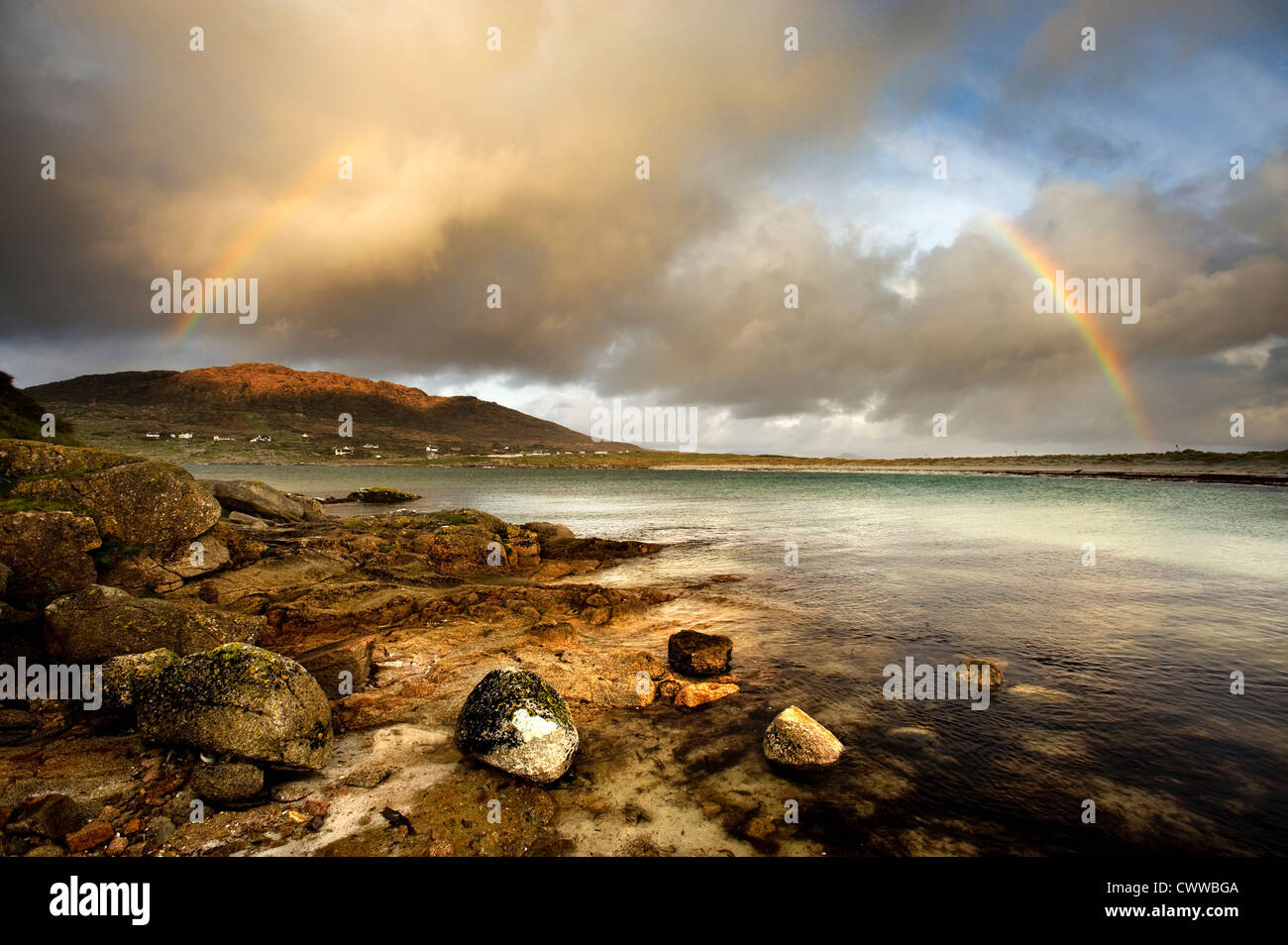 Rainbow stretching over still rural lake Stock Photo - Alamy