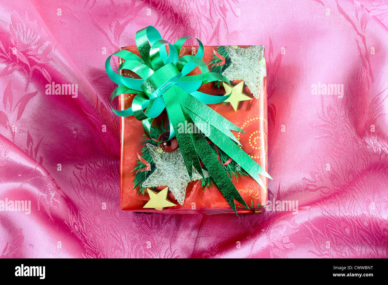 red gift box with green ribbon on pink satin Stock Photo - Alamy
