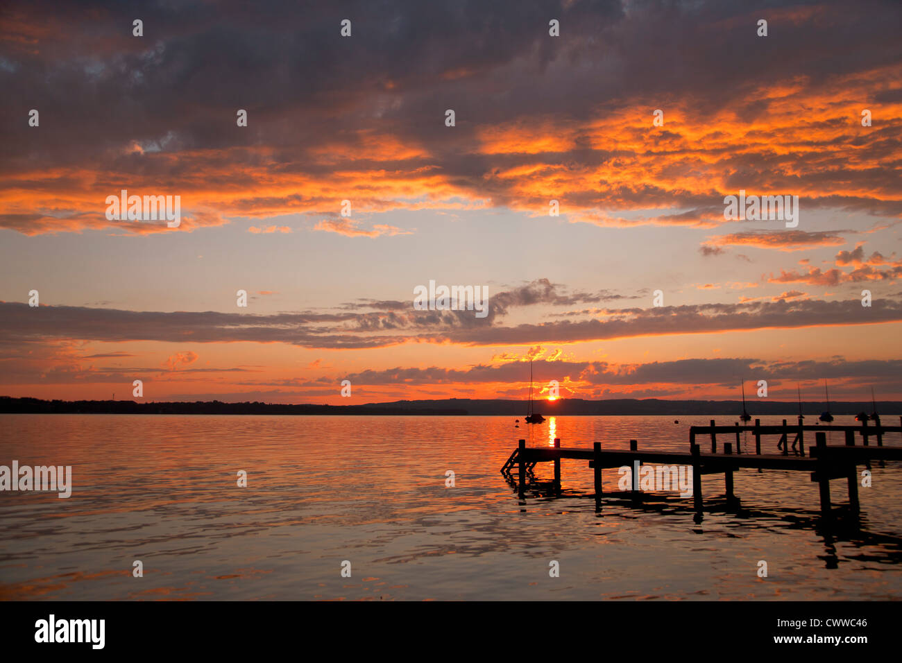 Sun setting over still rural lake Stock Photo - Alamy