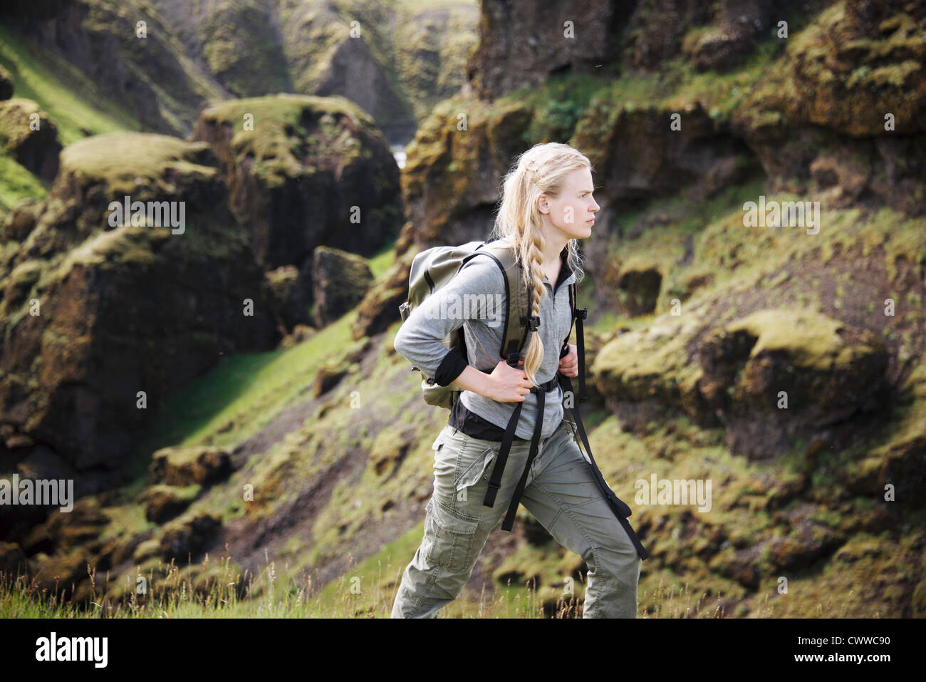 Hiker wearing backpack on mountainside Stock Photo - Alamy