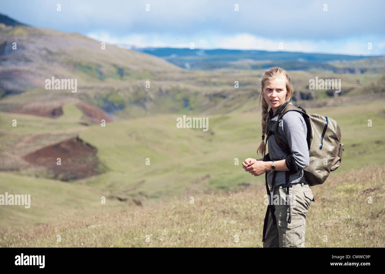Hiker wearing backpack on hillside Stock Photo - Alamy