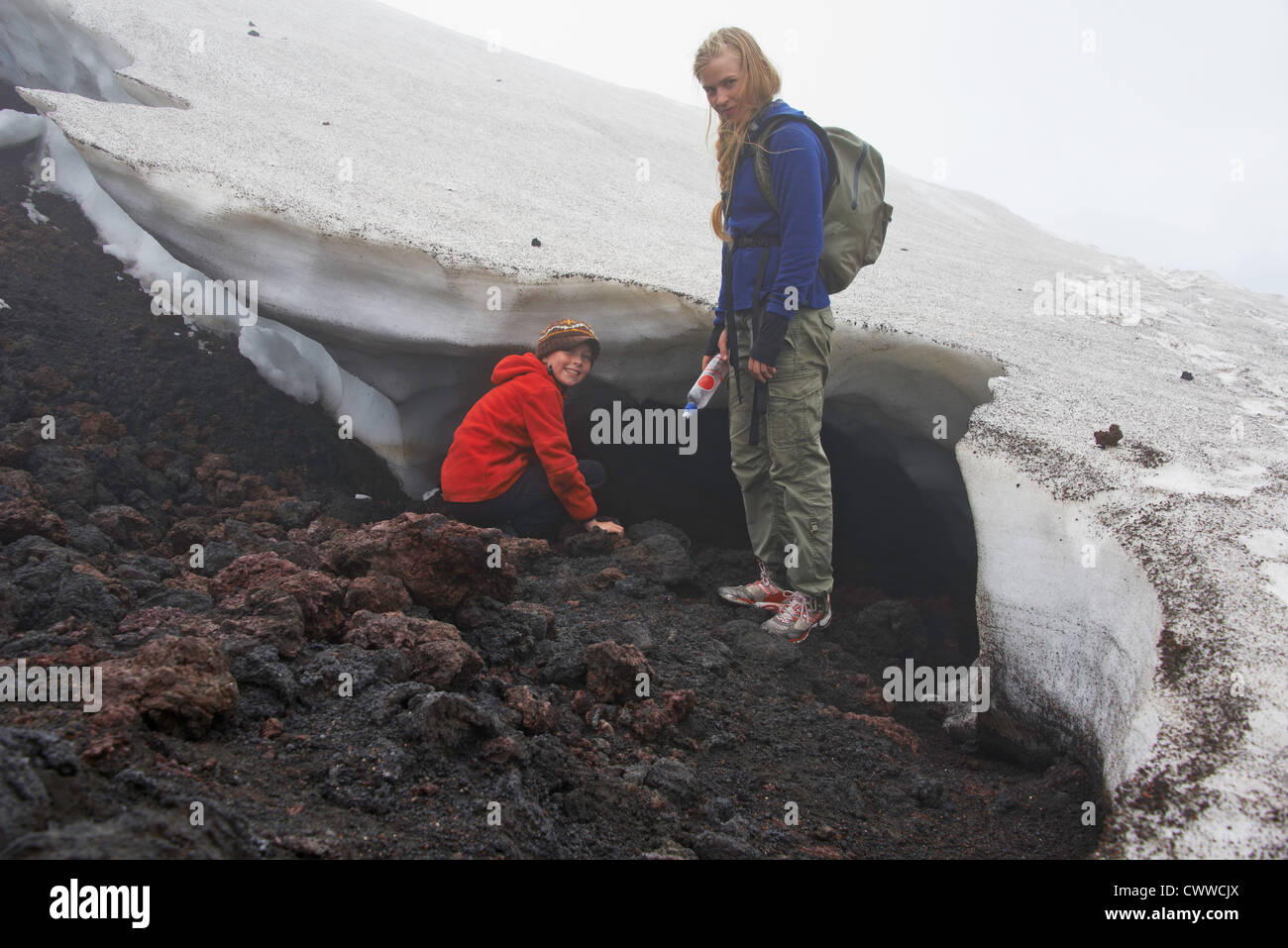 Mother and daughter exploring snow drift Stock Photo - Alamy